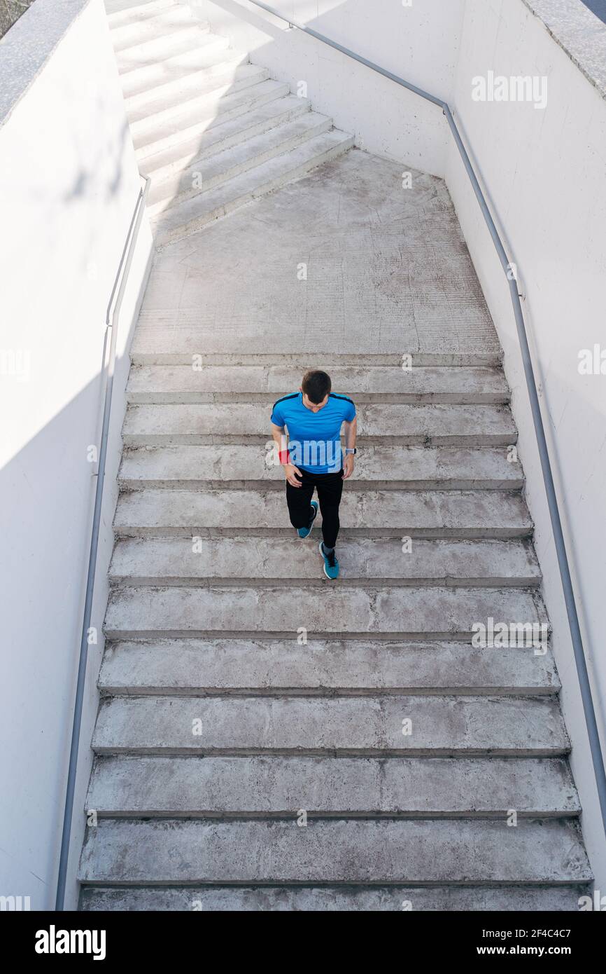 Young man running upstairs on city stairs. Fitness, sport, people ...