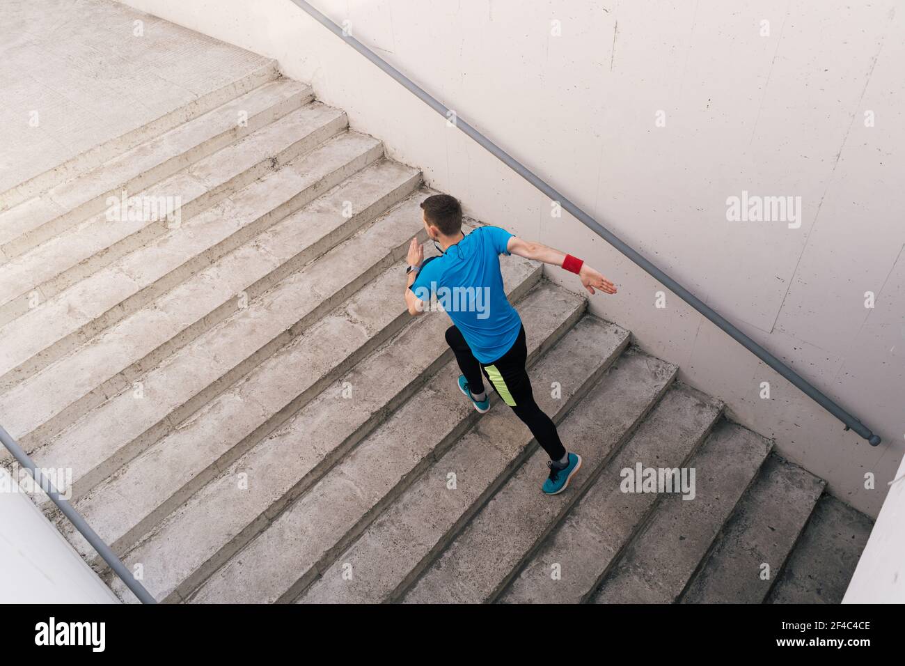 Young man running upstairs on city stairs. Fitness, sport, people ...