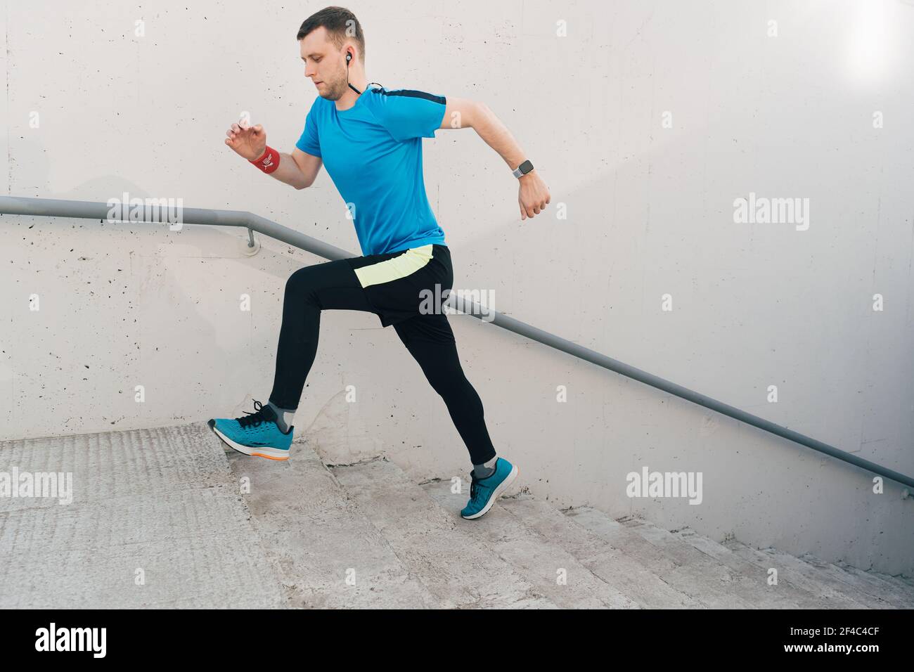 Young man running upstairs on city stairs. Fitness, sport, people ...