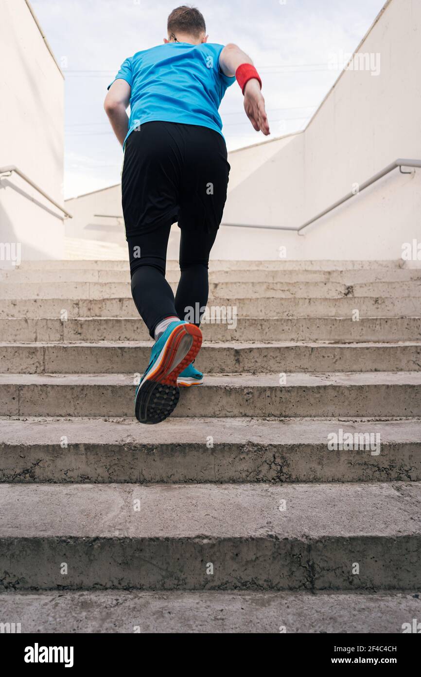 Young man running upstairs on city stairs. Fitness, sport, people ...