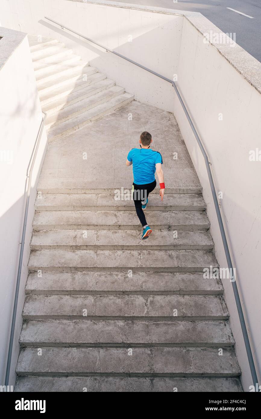 Young man running upstairs on city stairs. Fitness, sport, people ...