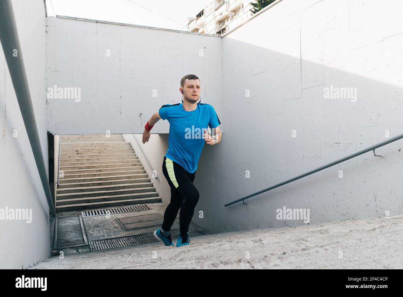 Young man running upstairs on city stairs. Fitness, sport, people ...