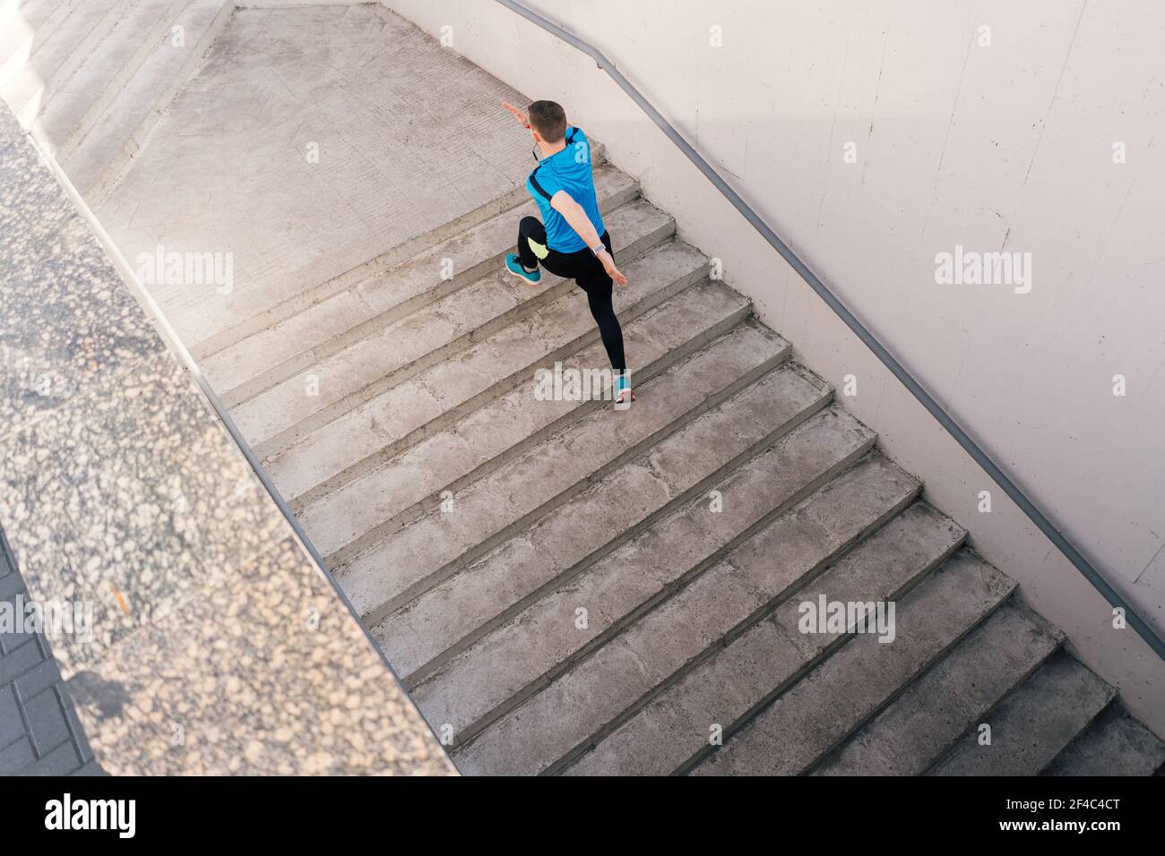 Young man running upstairs on city stairs. Fitness, sport, people ...