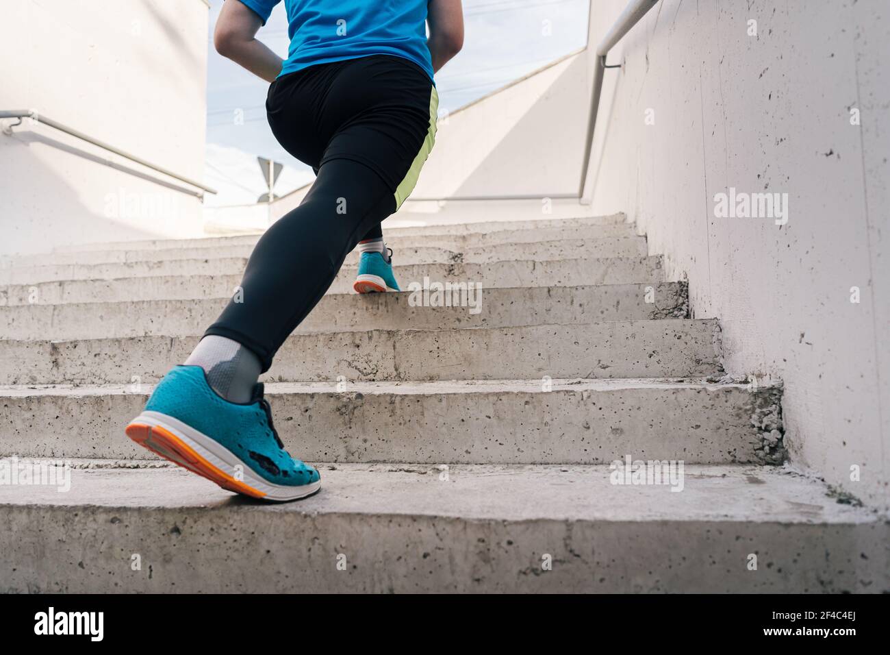 Young man runner getting ready to run stretching legs warm up quad ...
