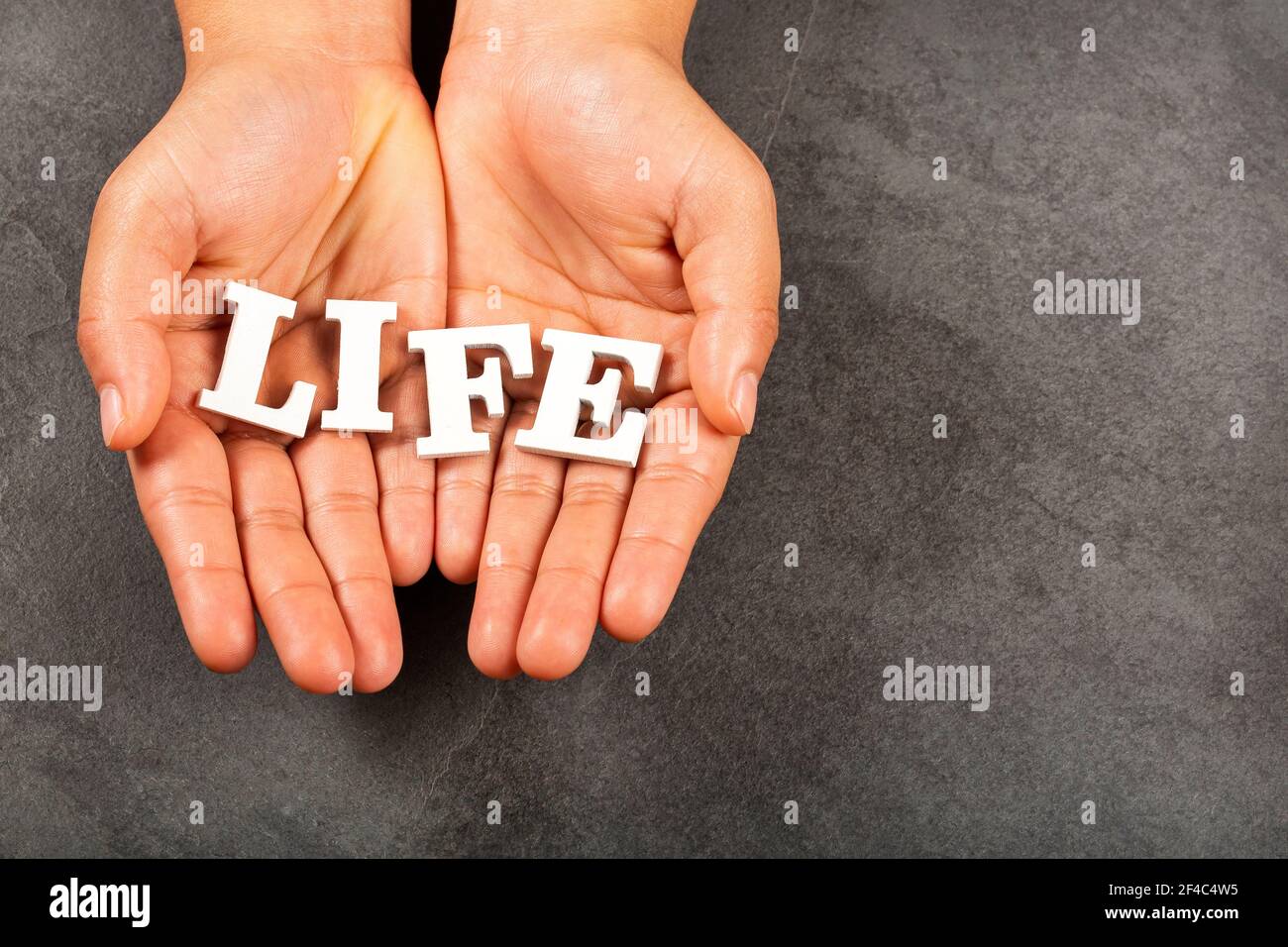 Hands holding wooden letters word life Stock Photo - Alamy