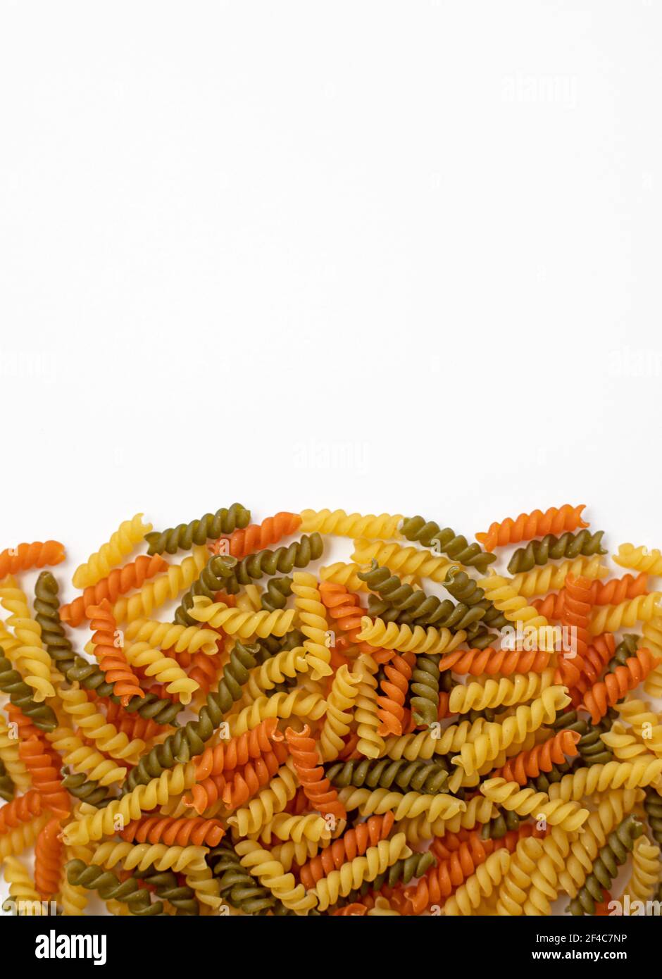 Tricolor, dry and raw pasta on a white background Stock Photo - Alamy