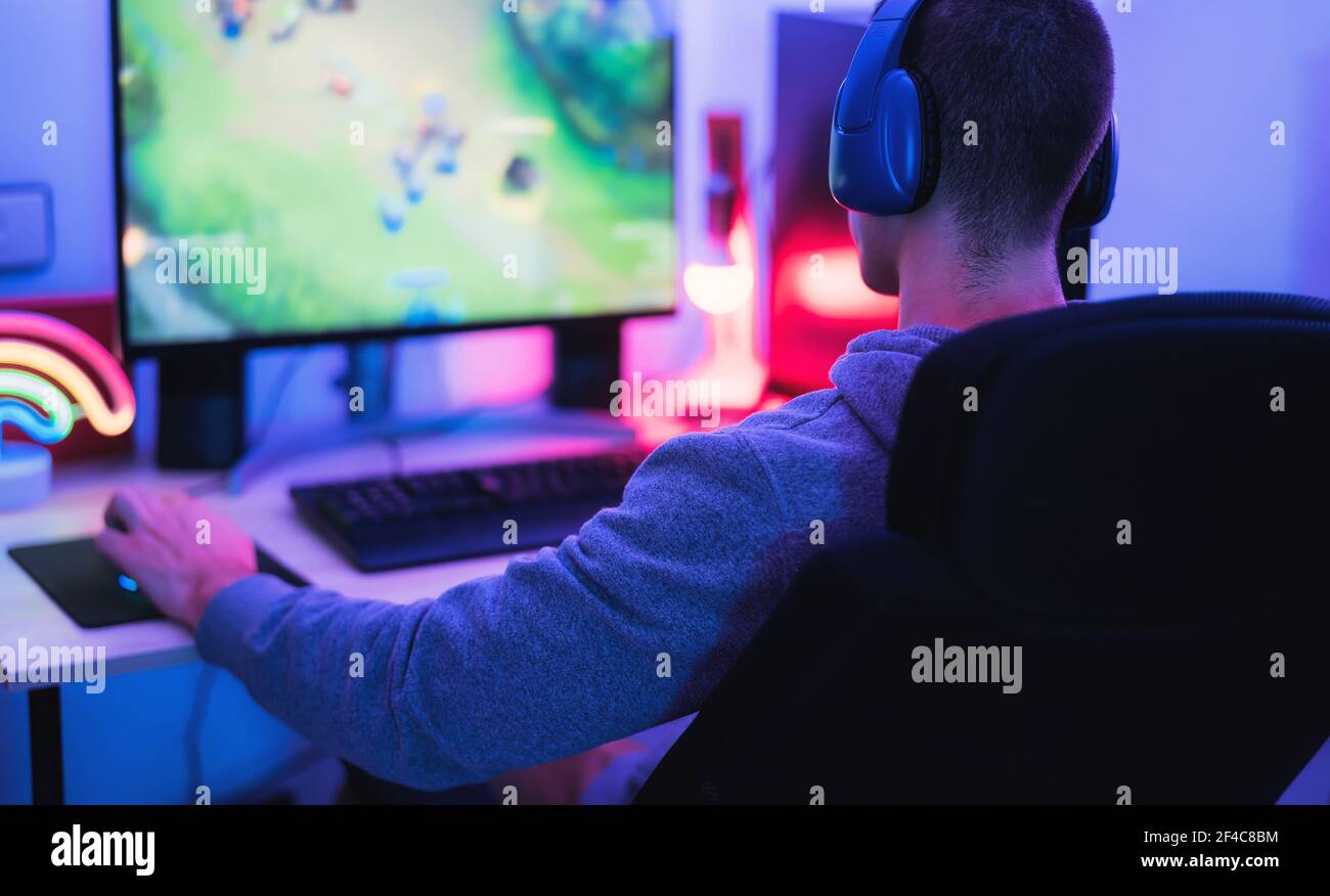 Young gamer playing online video games while streaming on social media ...