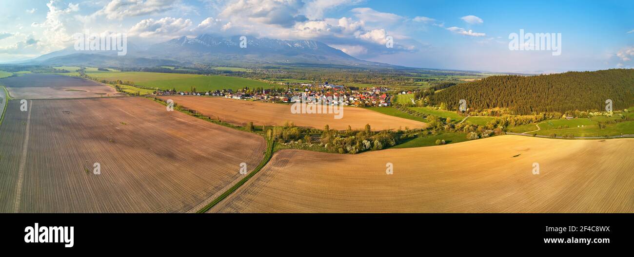Spring sunny mountain panorama. Village in green forest hills ...