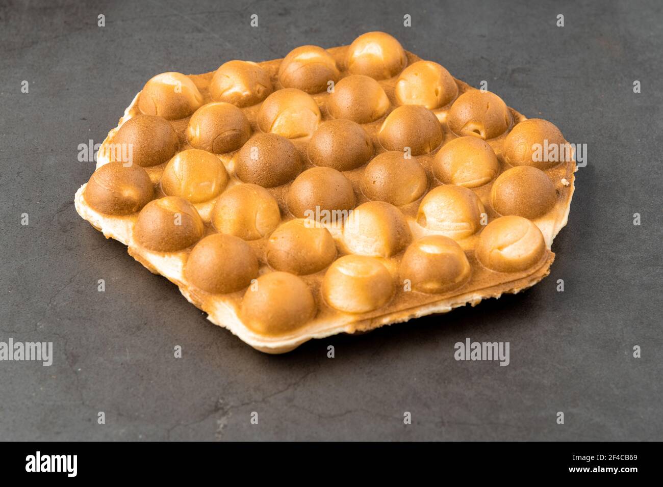 bubble waffle without topping on stone background Stock Photo - Alamy