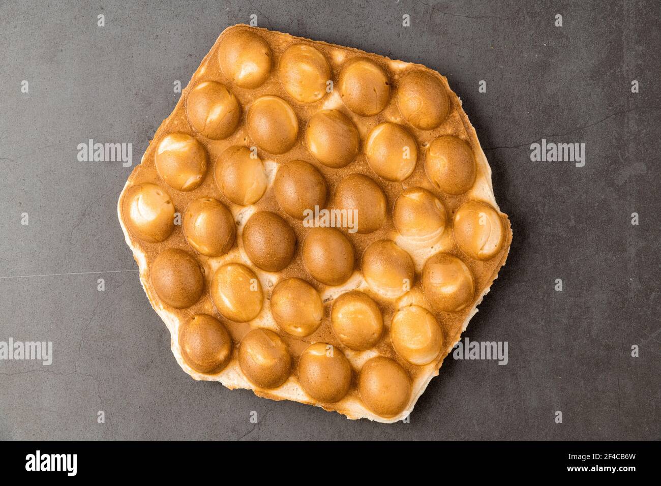 bubble waffle without topping on stone background Stock Photo - Alamy