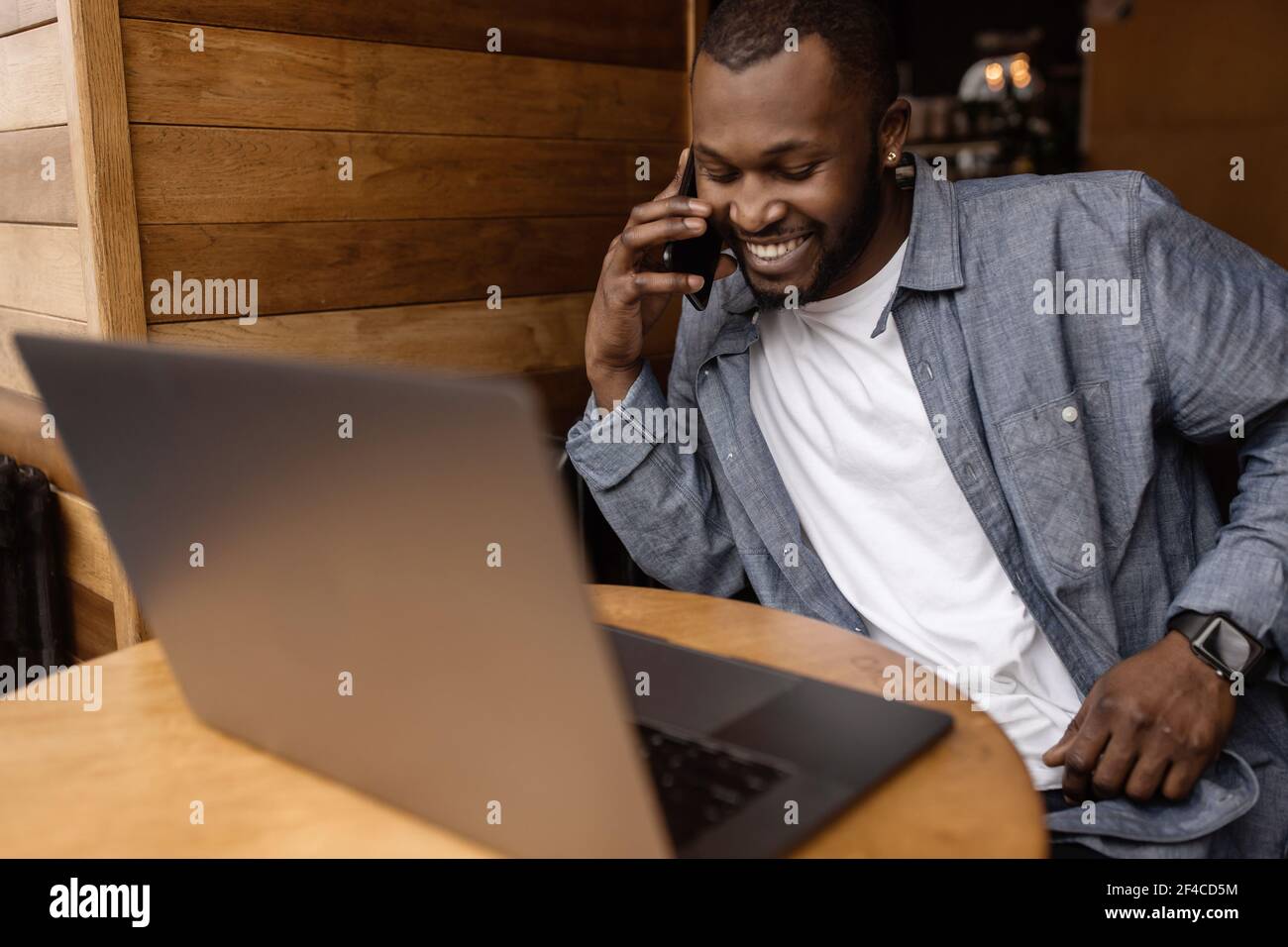 Handsome businessman is having a conversation by smartphone, smiling ...