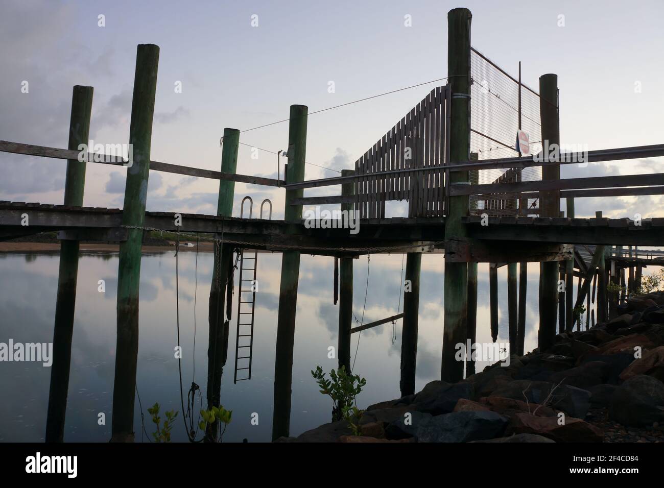 The old fishing boat wharf which is ready for demolition at dawn on a ...