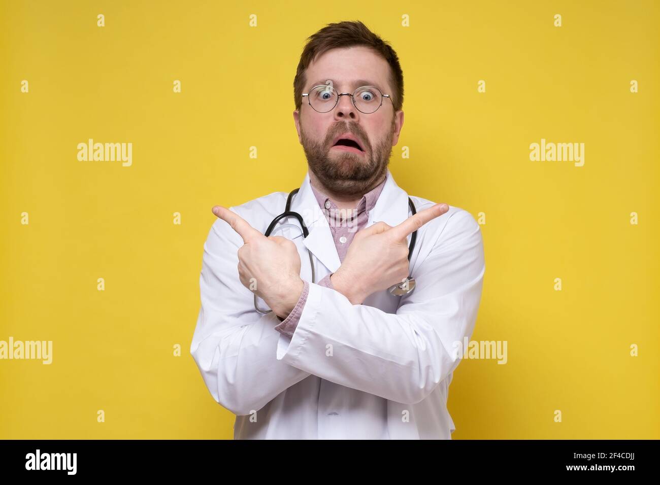 Bizarre, stunned male doctor points index fingers in different ...