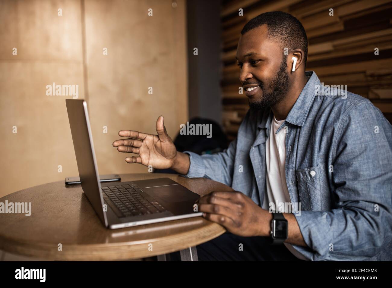 Friendly African American using a laptop, looking at the screen ...
