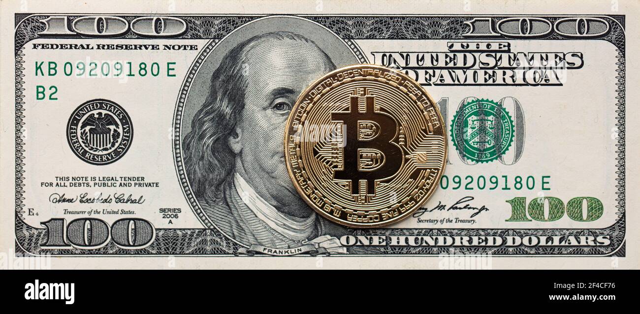 Bitcoin on 100 dollar banknote background Stock Photo - Alamy