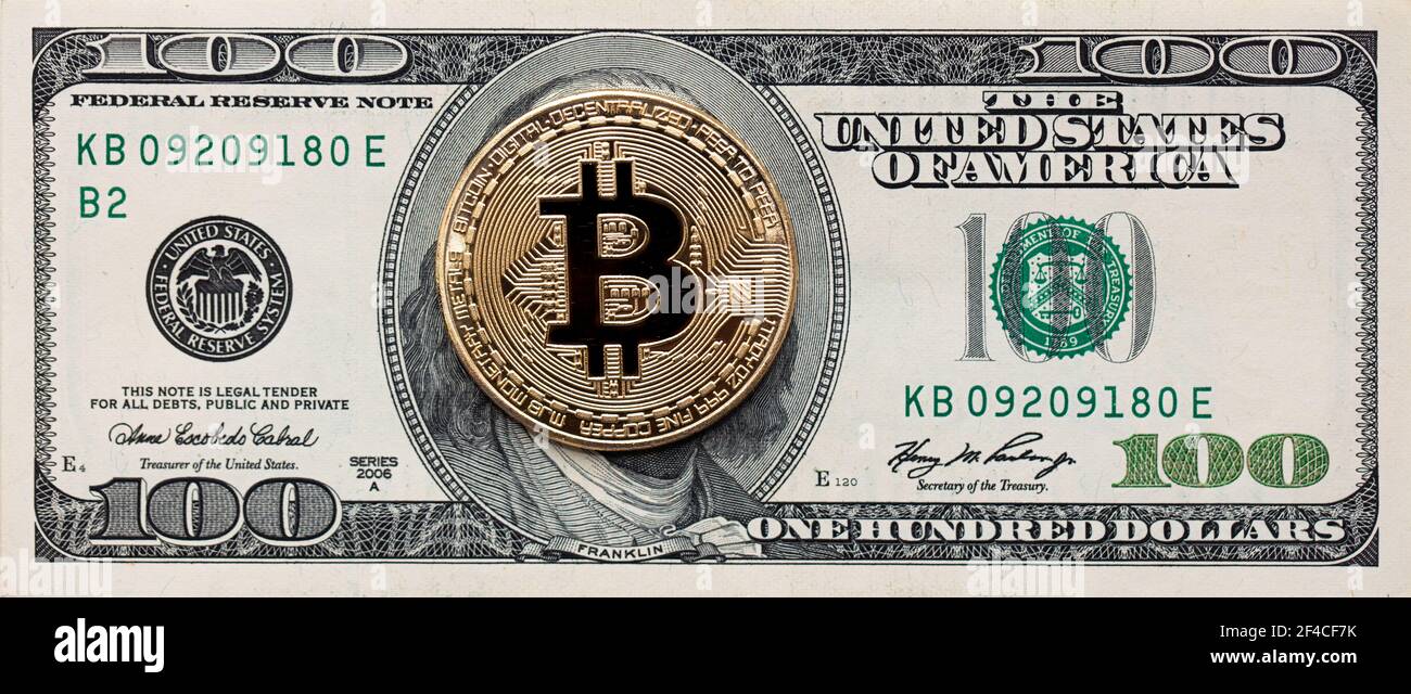 Bitcoin on 100 dollar banknote background Stock Photo - Alamy