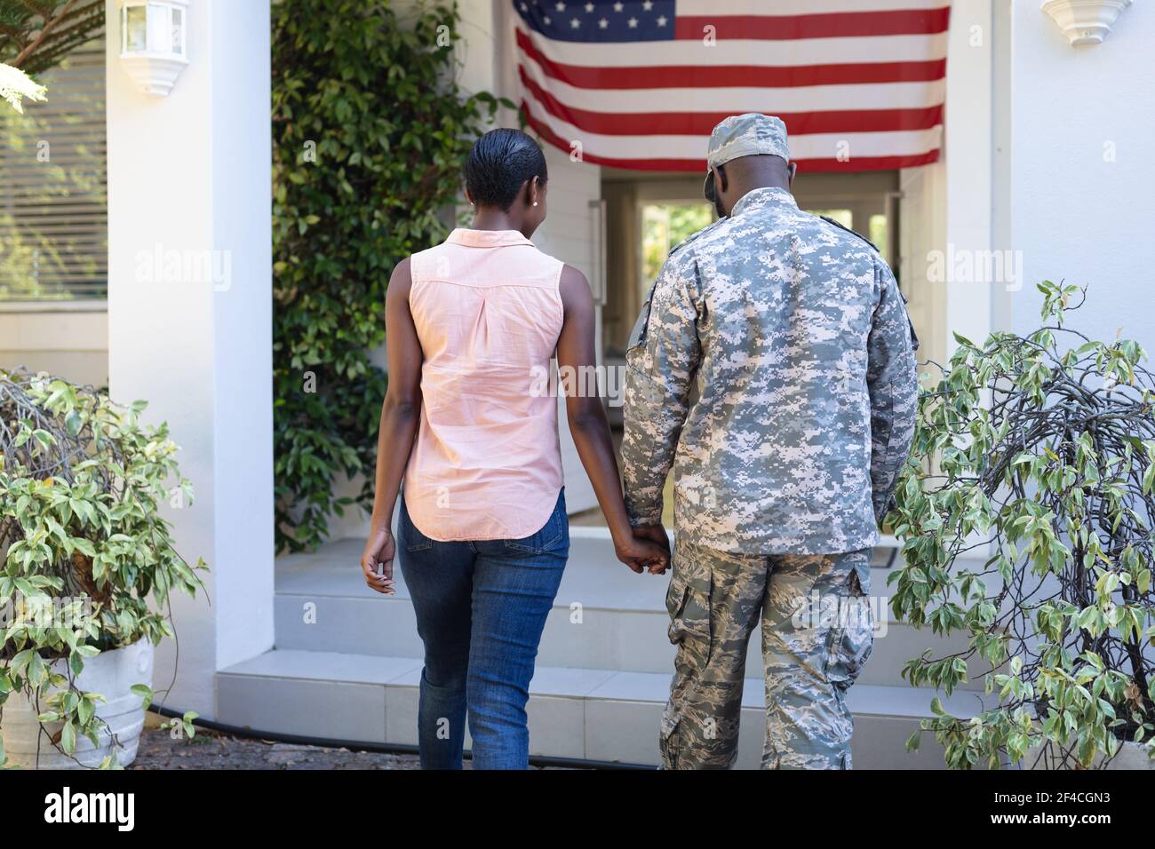 Rear view of african american male soldier and wife standing holding ...