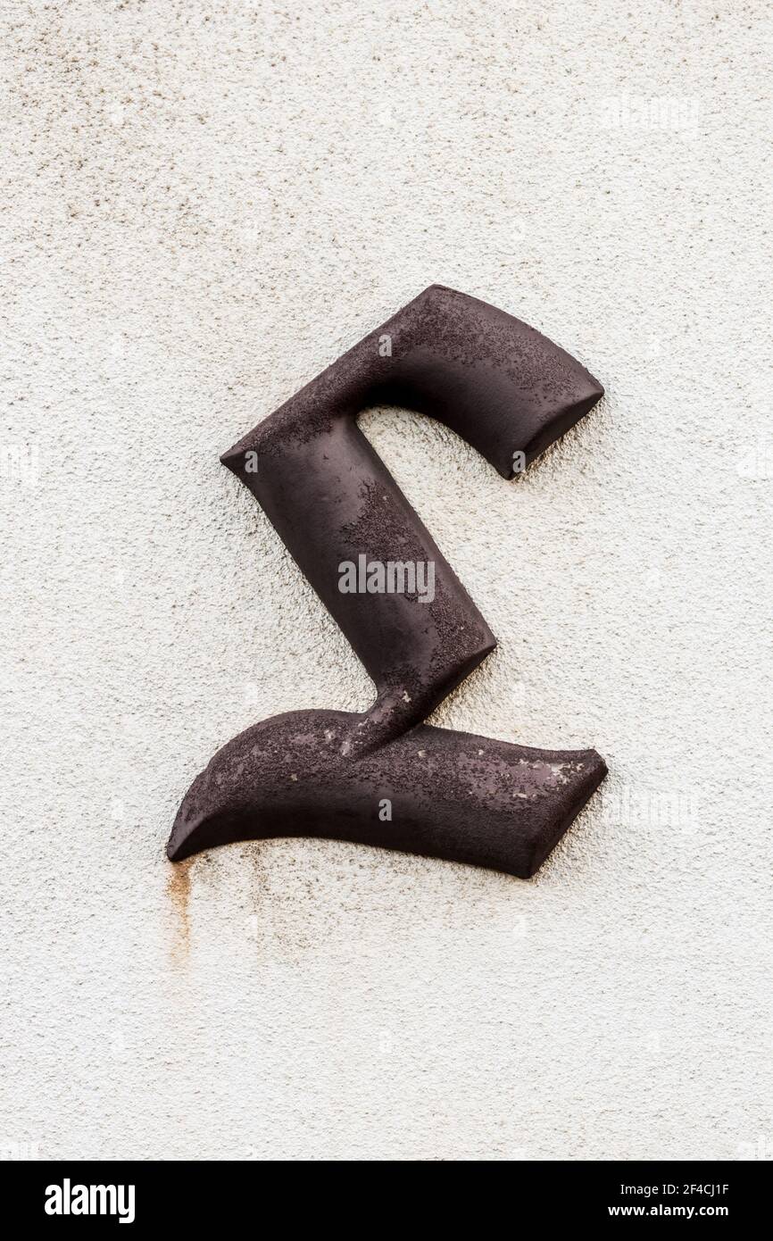 Historic black letter L in brown colour on light wall Stock Photo - Alamy