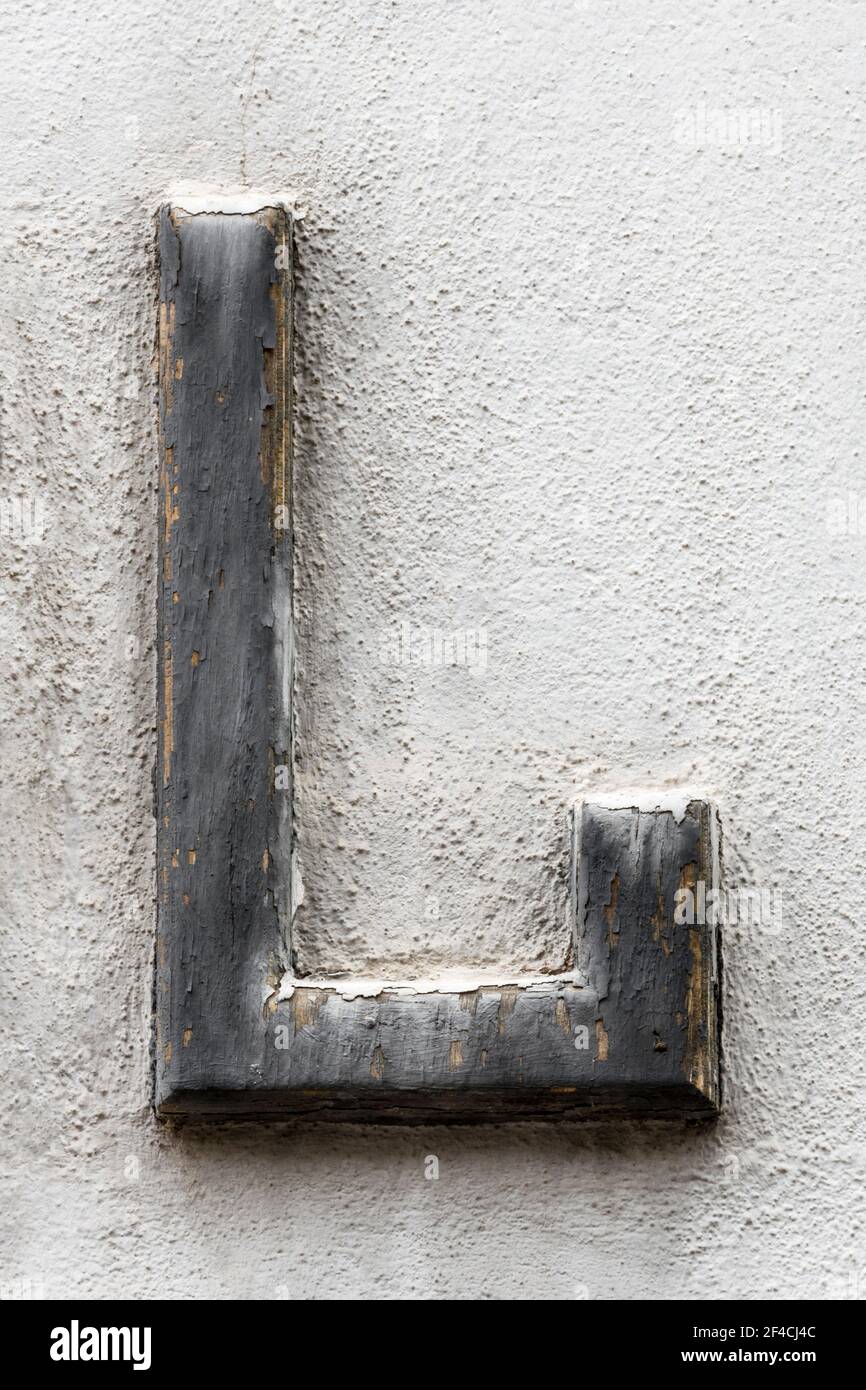 Wooden letter L with peeling black paint Stock Photo - Alamy