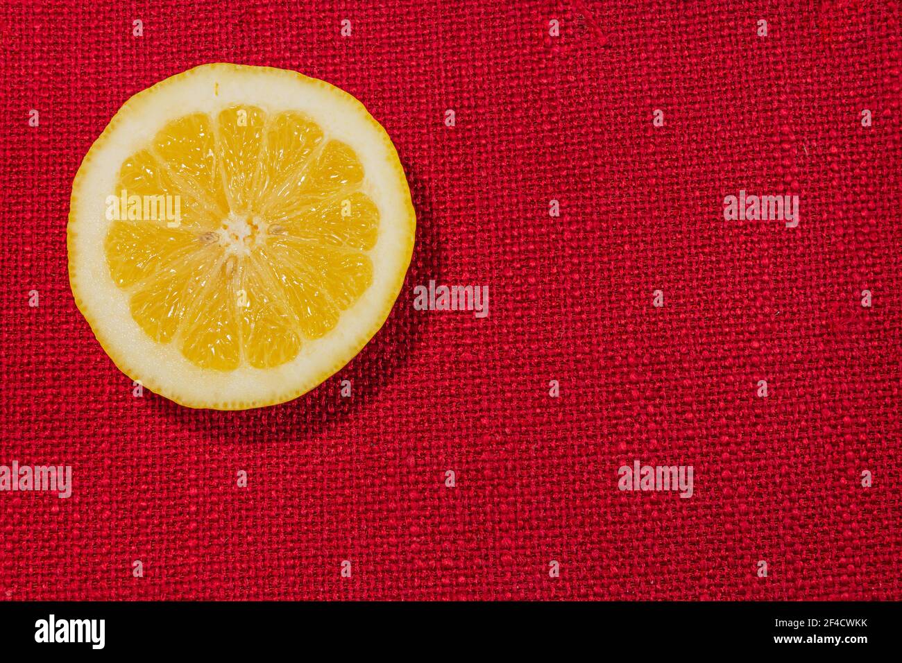 Detail of fresh sliced lemon on a rustic canvas fabric texture in Ruby ...