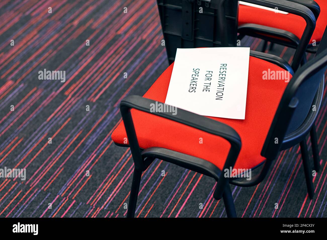Red and black conference chairs in the auditorium with reservation for ...