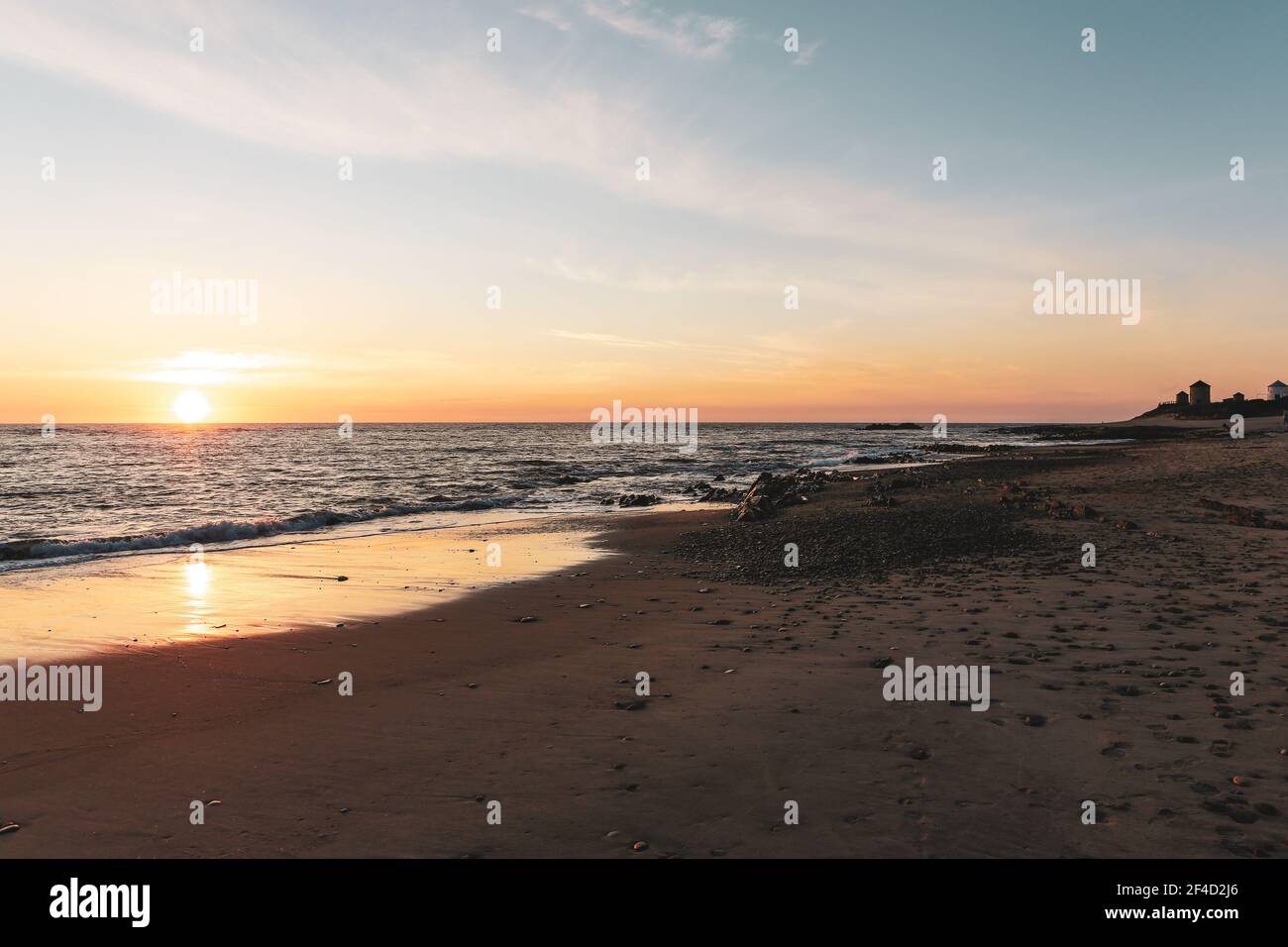 A beautiful quiet and calm beach during an orange sunset Stock Photo ...
