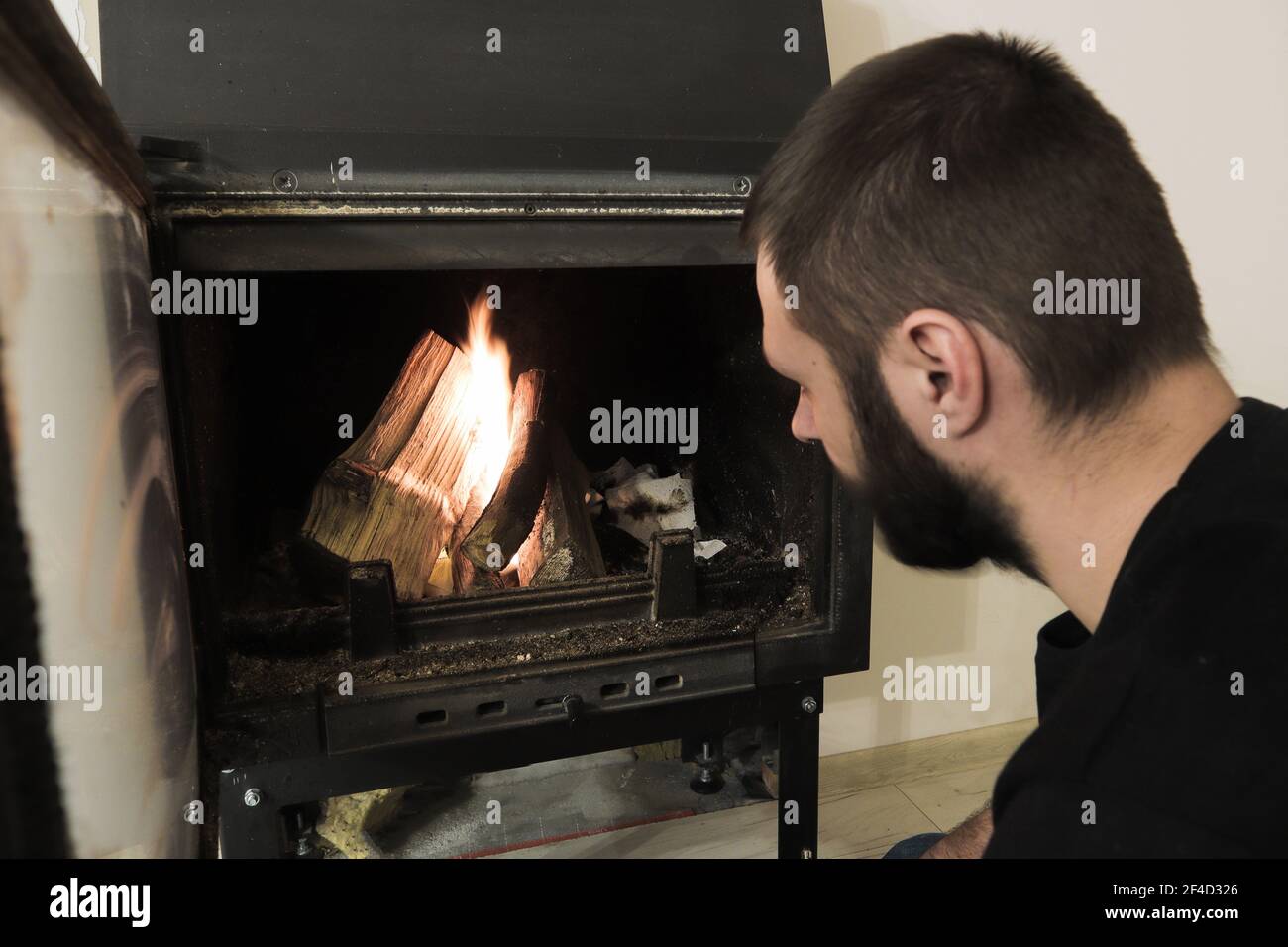 Man starting up wood stove hi-res stock photography and images - Alamy