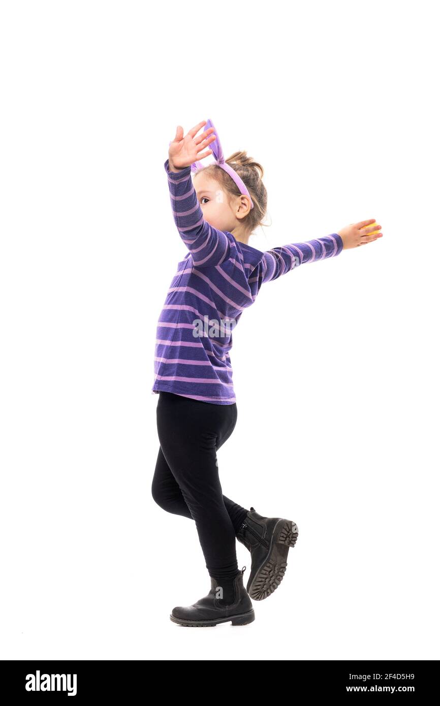 Side view of carefree playful young girl running like flying with open ...