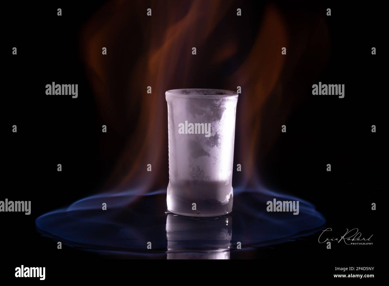 Glass in flames on a dark background with reflection Stock Photo - Alamy