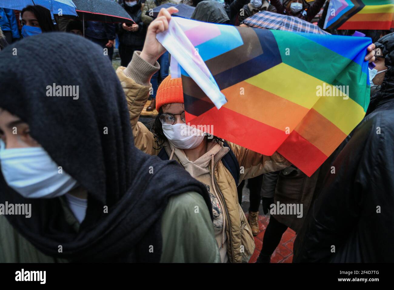 A protester wearing a face mask holds an LGBTI flag during the ...