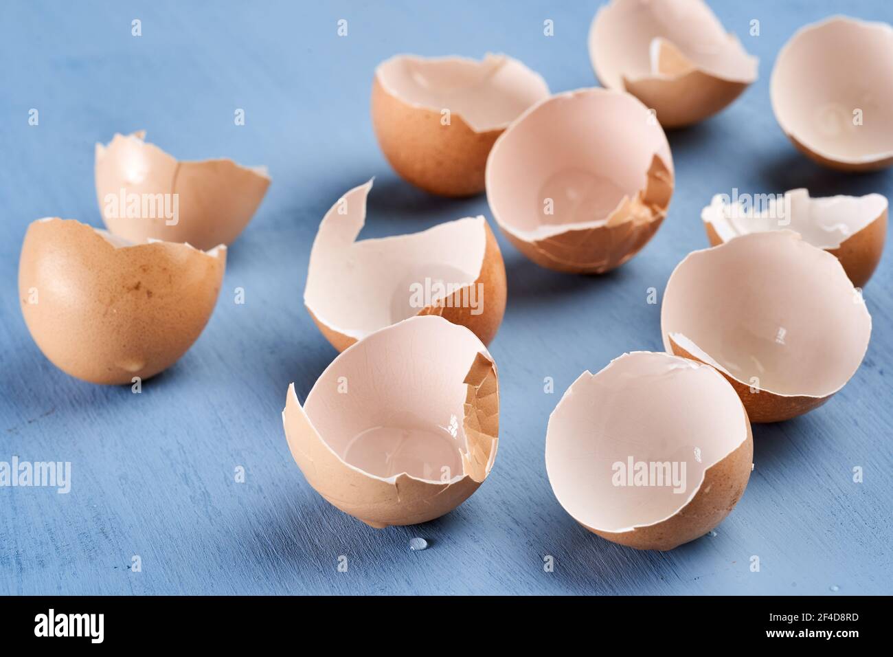 Broken egg shells on blue background Stock Photo - Alamy