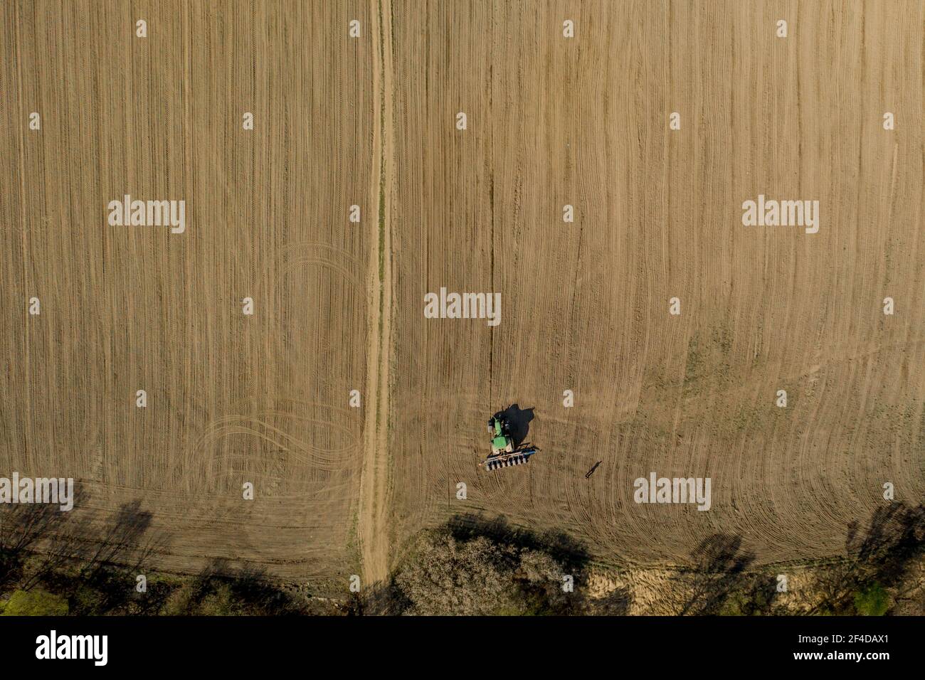 Aerial view large tractor cultivating a dry field. Top down aerial view ...