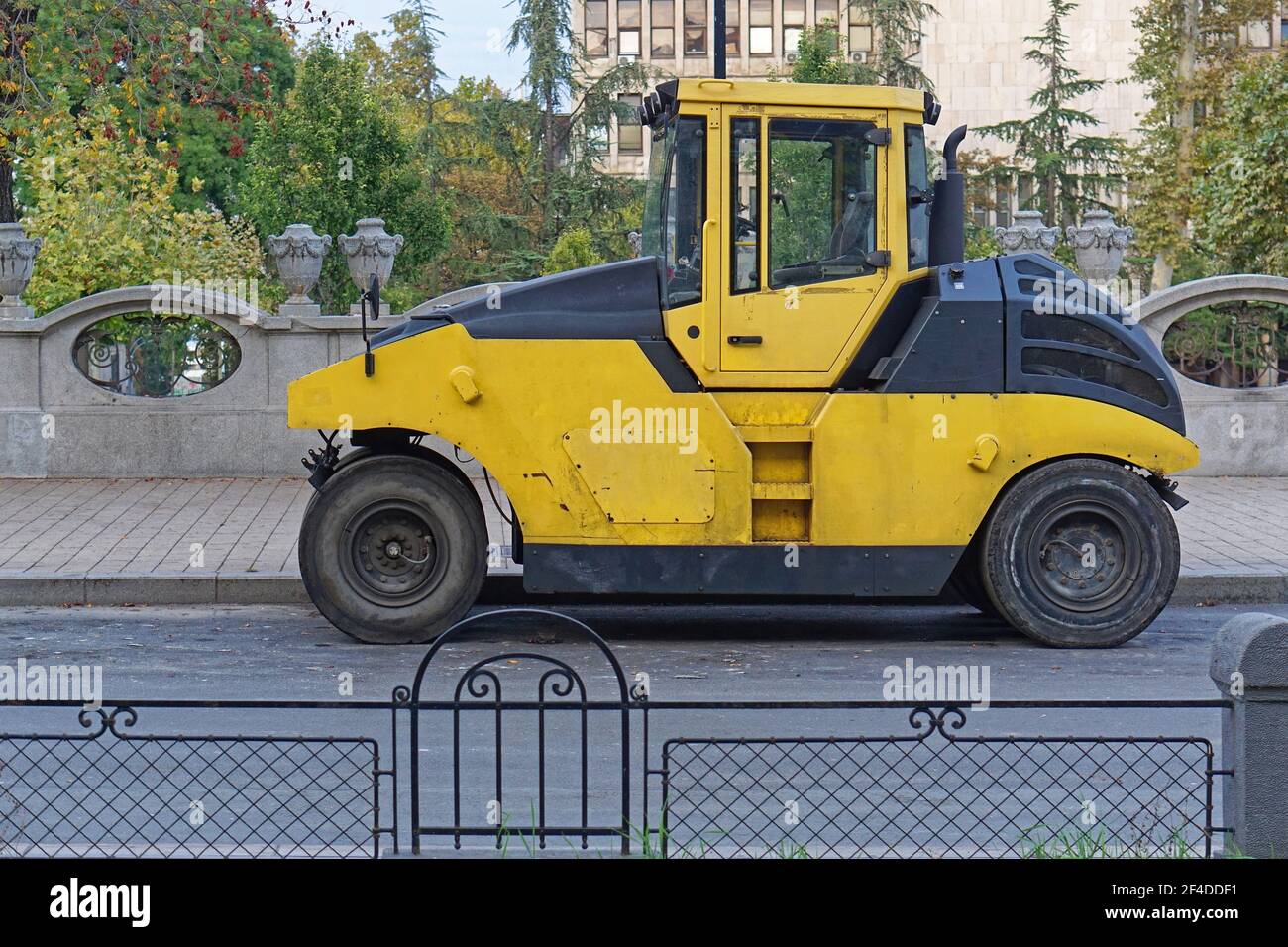 Big yellow road roller at street construction site Stock Photo - Alamy