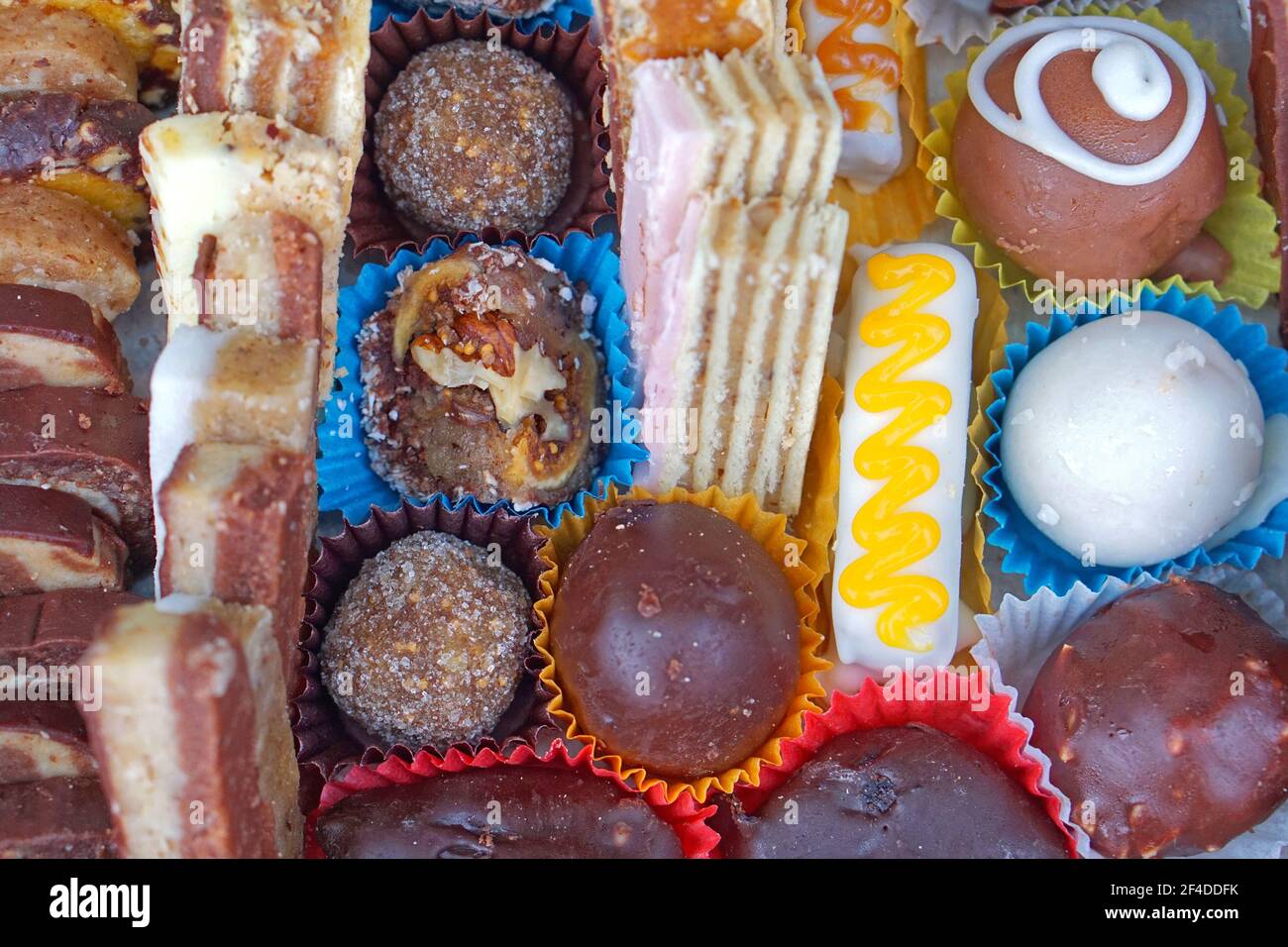 Many tiny cakes dessert selection in party box Stock Photo - Alamy