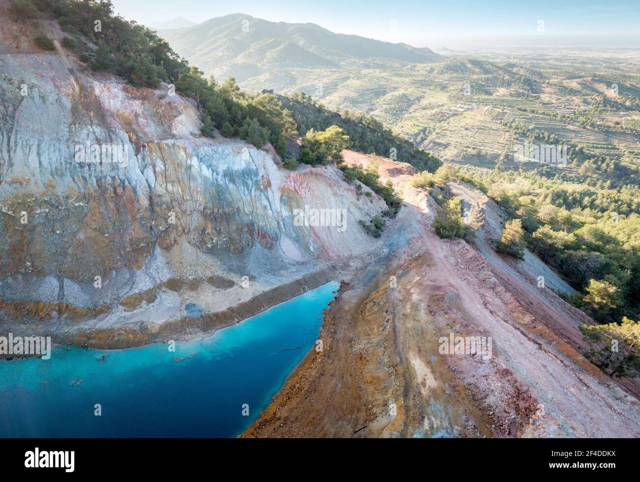 Aerial view of abandoned opencast Alestos mine in Cyprus. Blue lake and ...