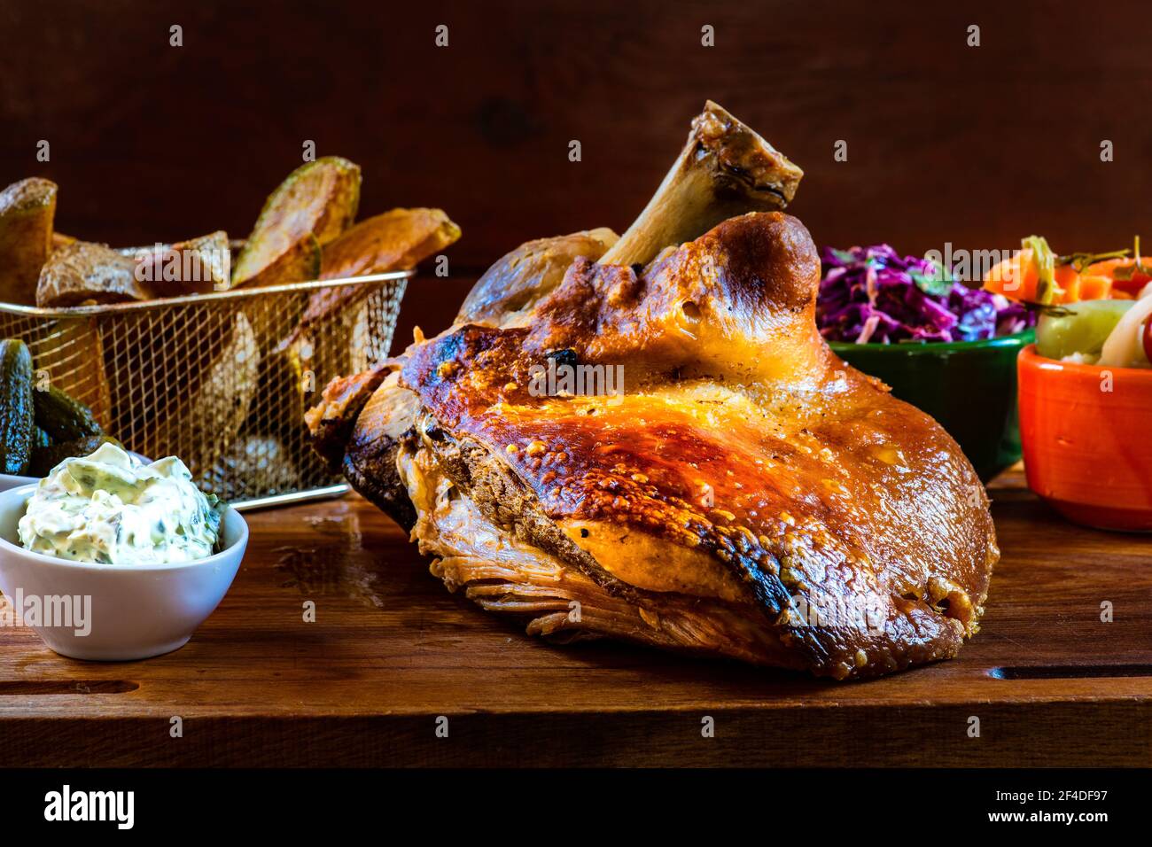 Roasted pork shin joint with chips, salad and coleslaw Stock Photo - Alamy