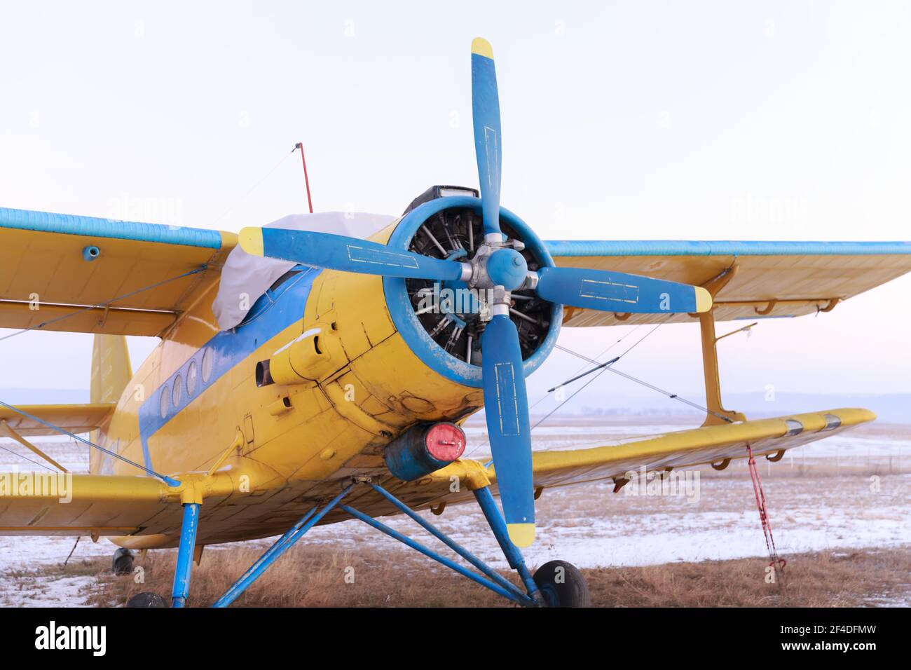 Old biplane plane with a huge aircraft propeller in a winter landscape ...
