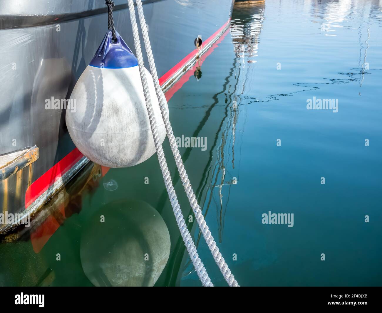 Close up with a white mooring ball and sailing rope Stock Photo - Alamy