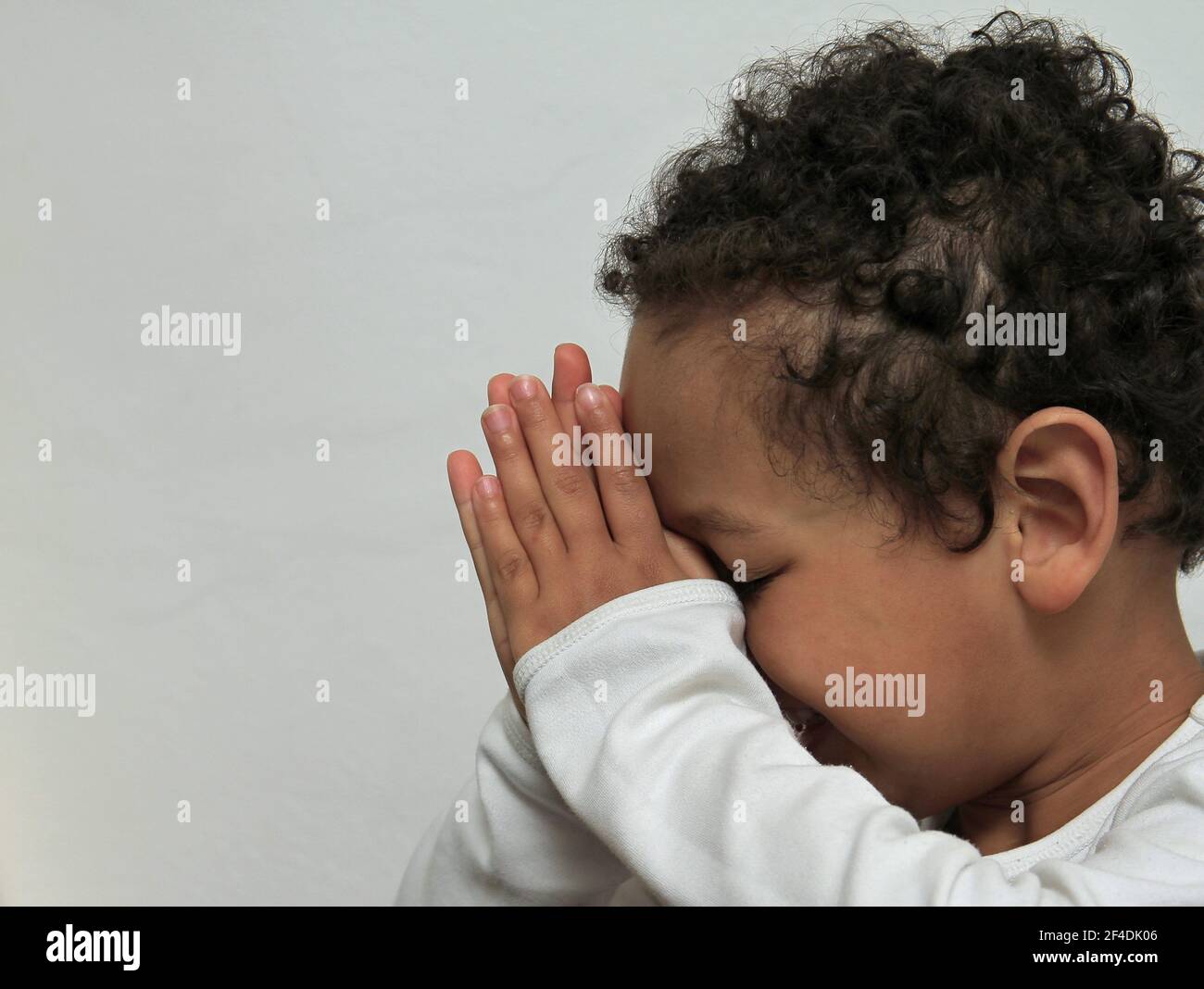 boy praying to God with hands together on white background stock photo ...
