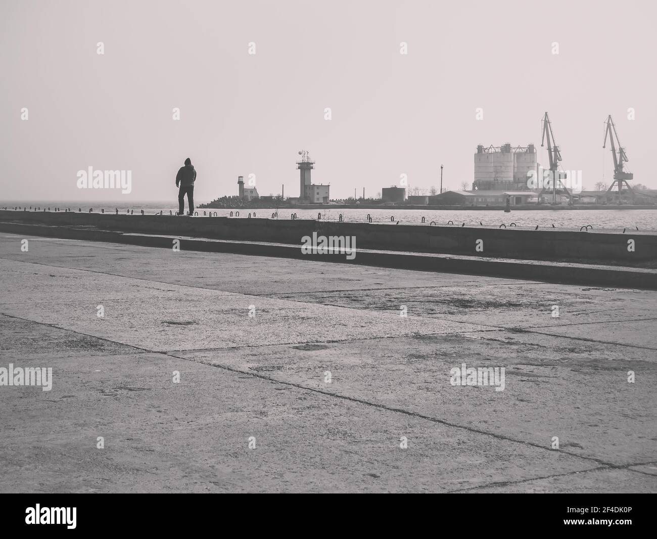 Moody scene with a lonely man walking on the seafront and the Mangalia ...