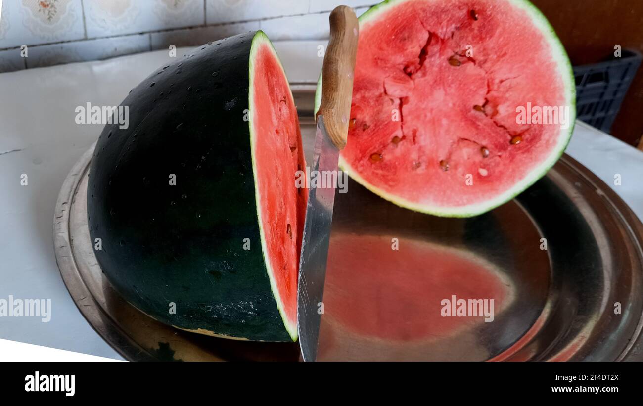 A ripe halved watermelon cut on a tray Stock Photo - Alamy