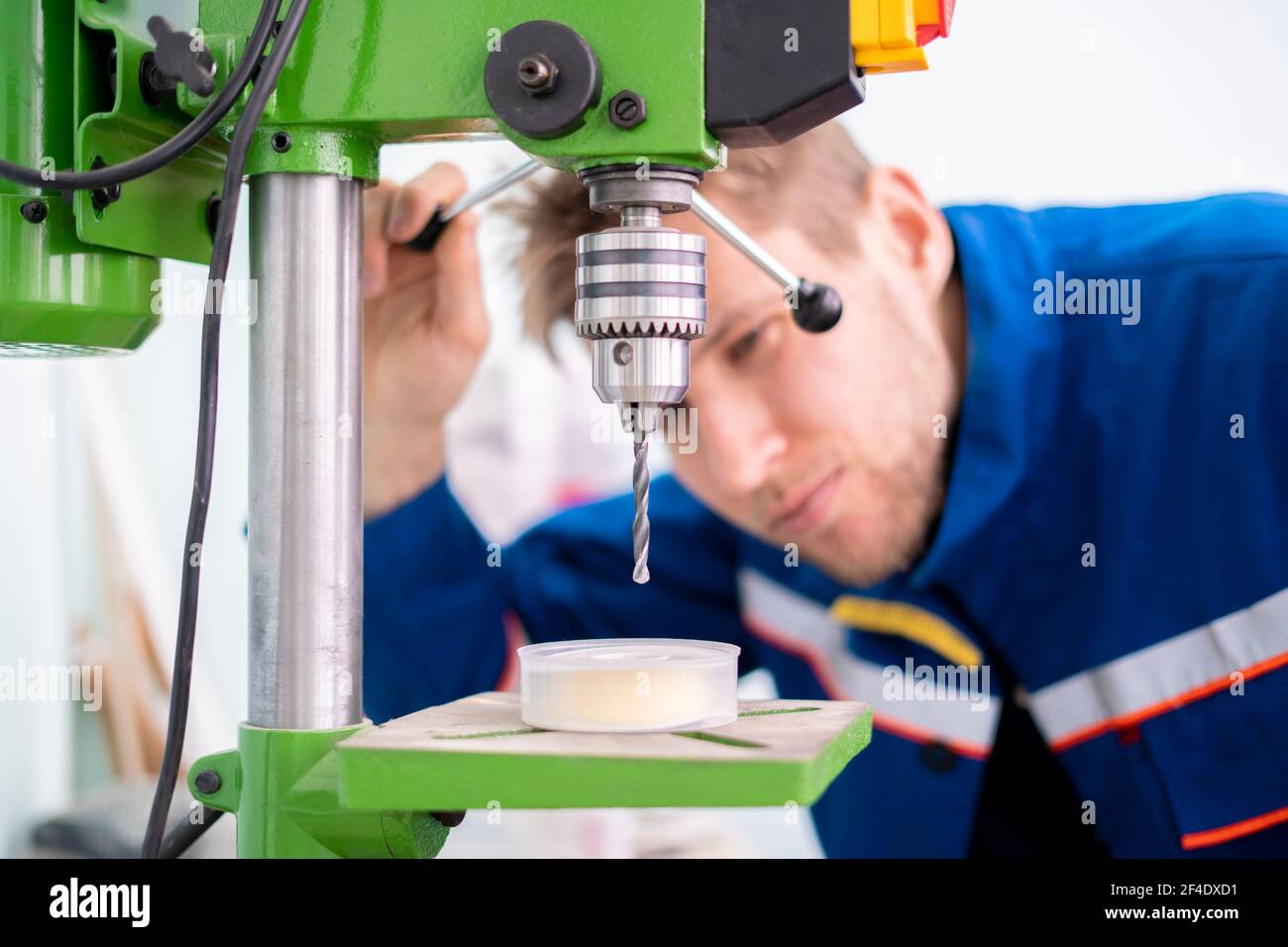 a close up young male worker using a drill machine on the factory Stock ...