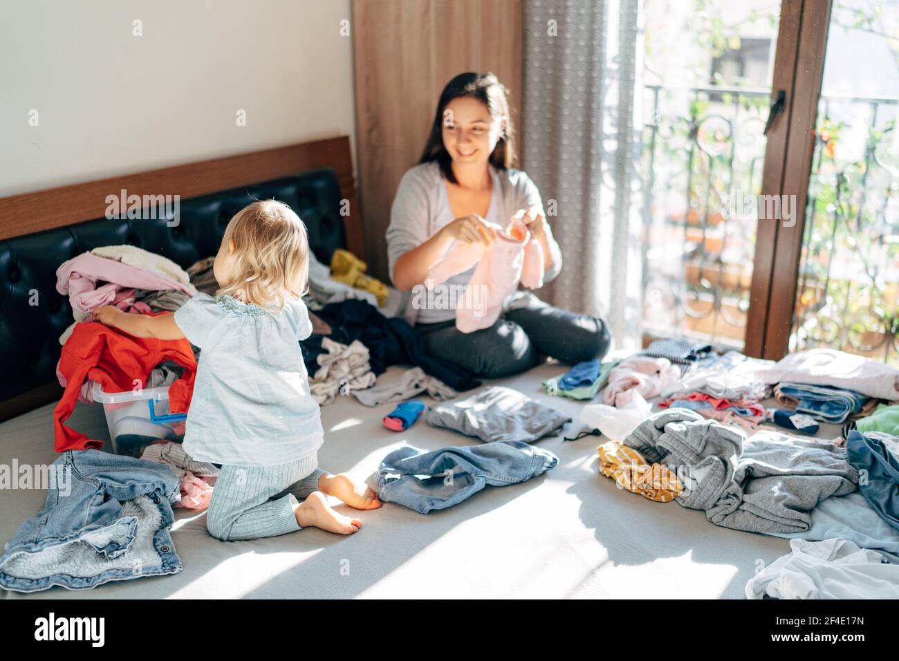 Mom and daughter are folding clothes home Stock Photo - Alamy