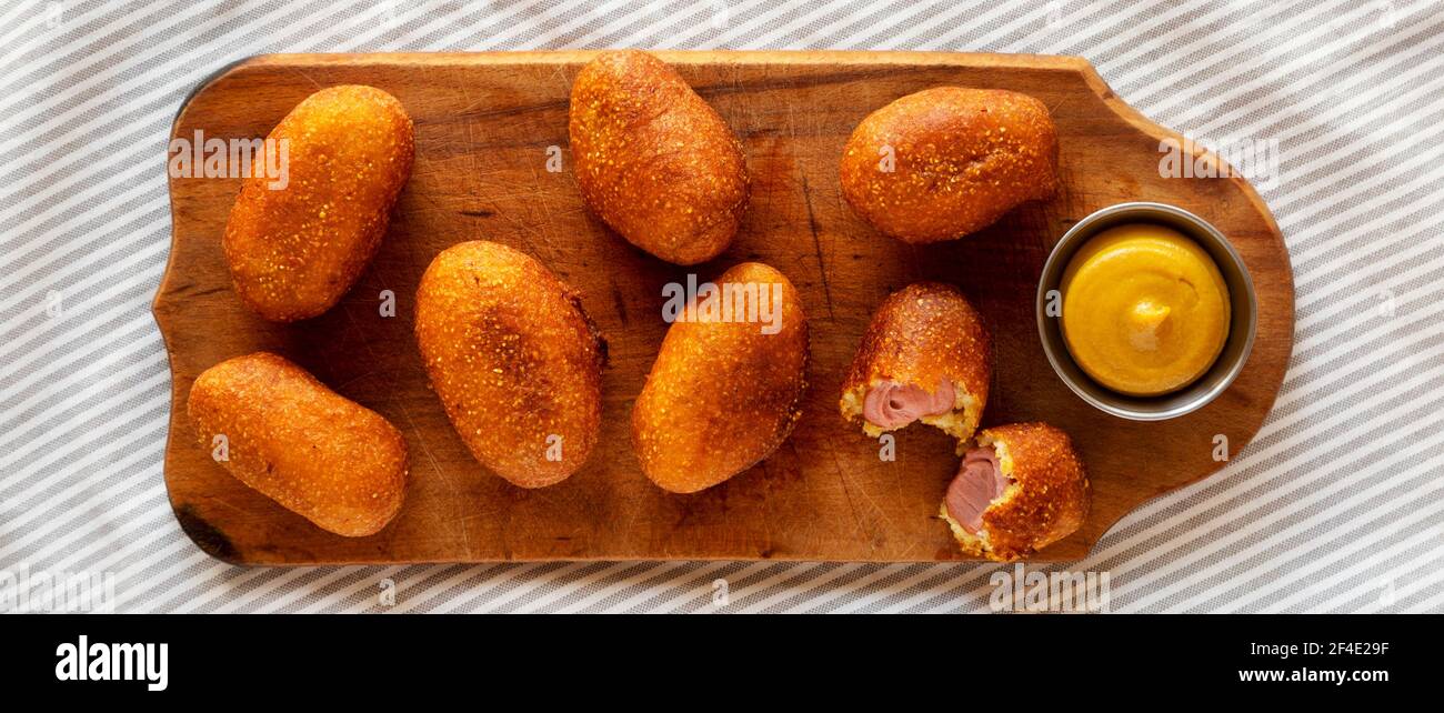 Homemade Mini Corn Dogs on a rustic wooden board, top view. Flat lay ...
