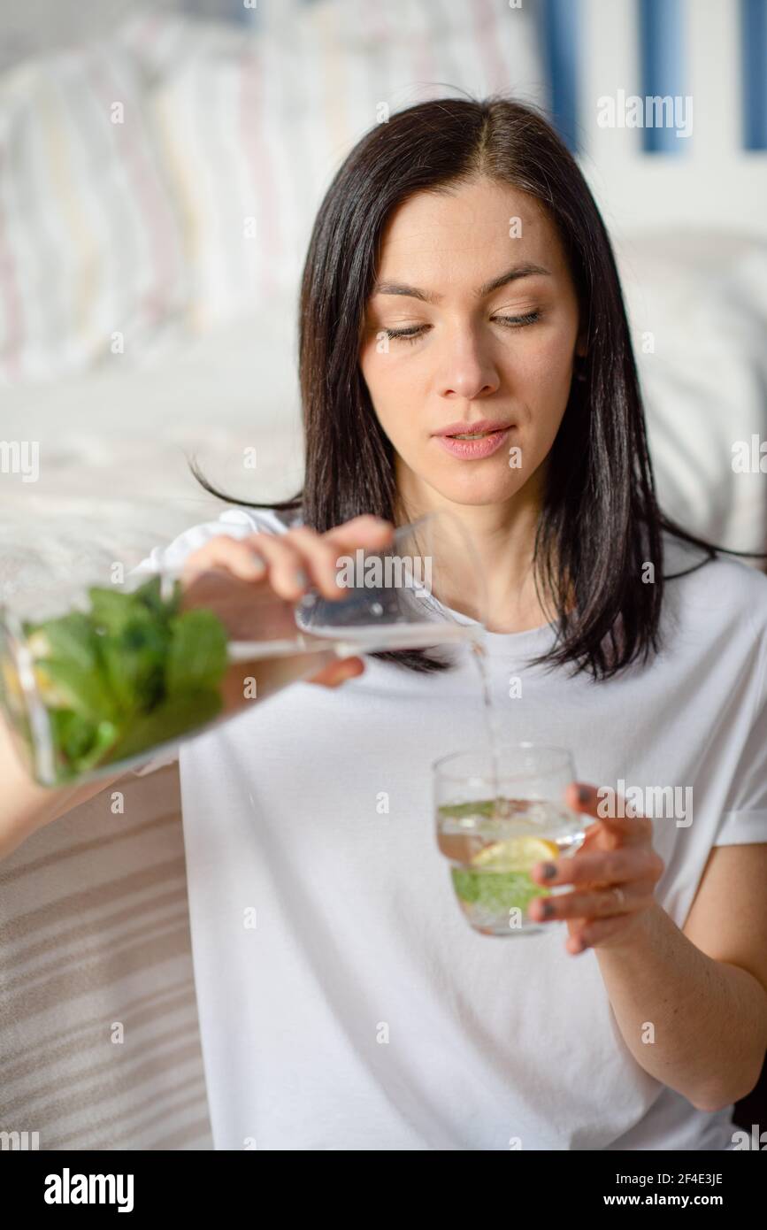 woman pouring fresh water into a glass from a decanter Stock Photo - Alamy