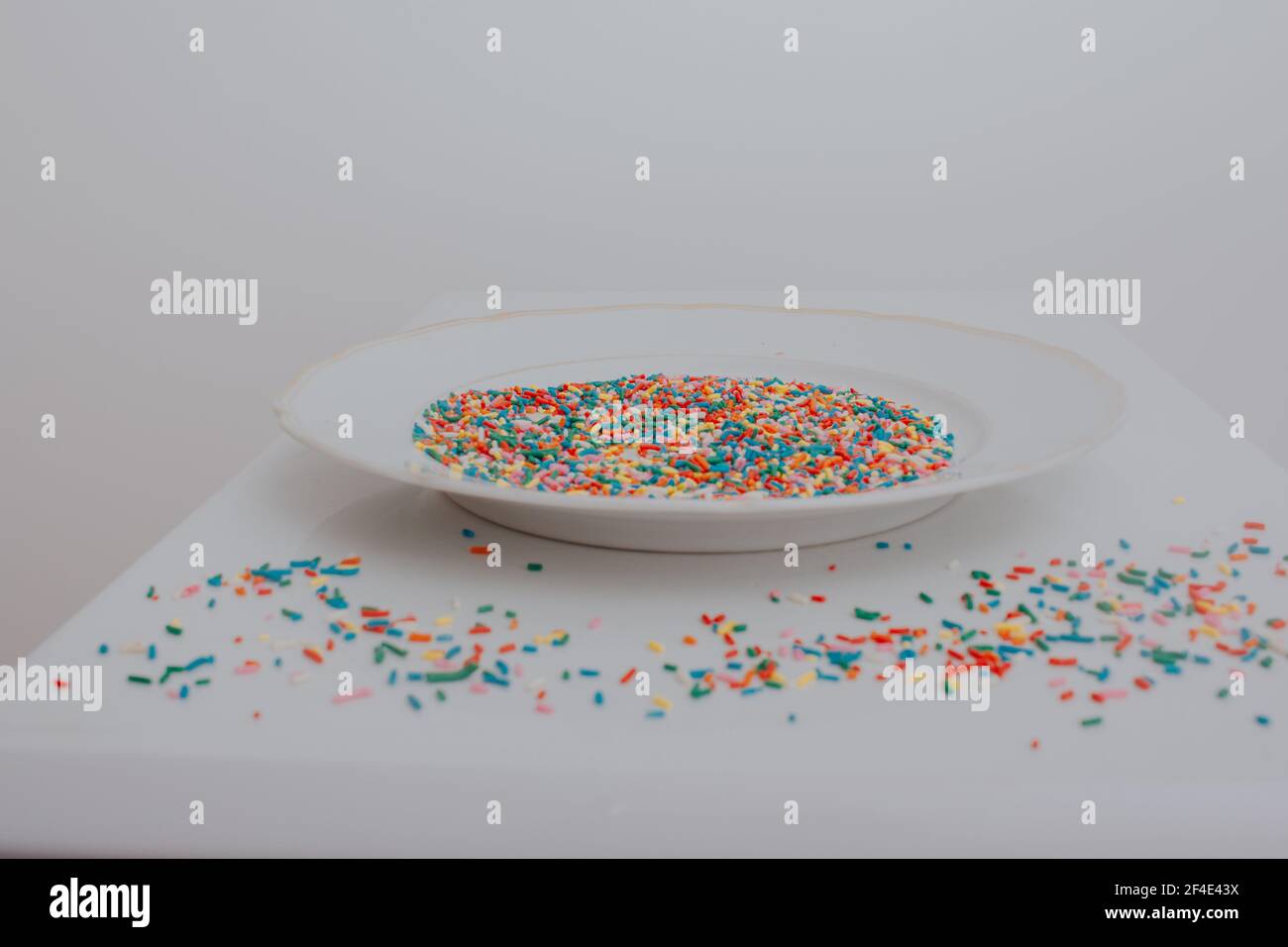 plate with colorful confetti on white background Stock Photo - Alamy