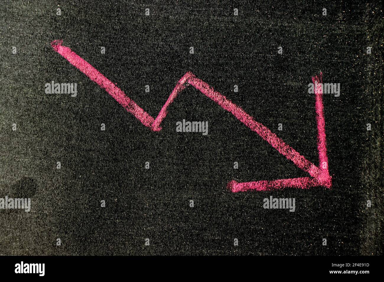 Red color chalk handdrawing in arrow down shape on blackboard or ...