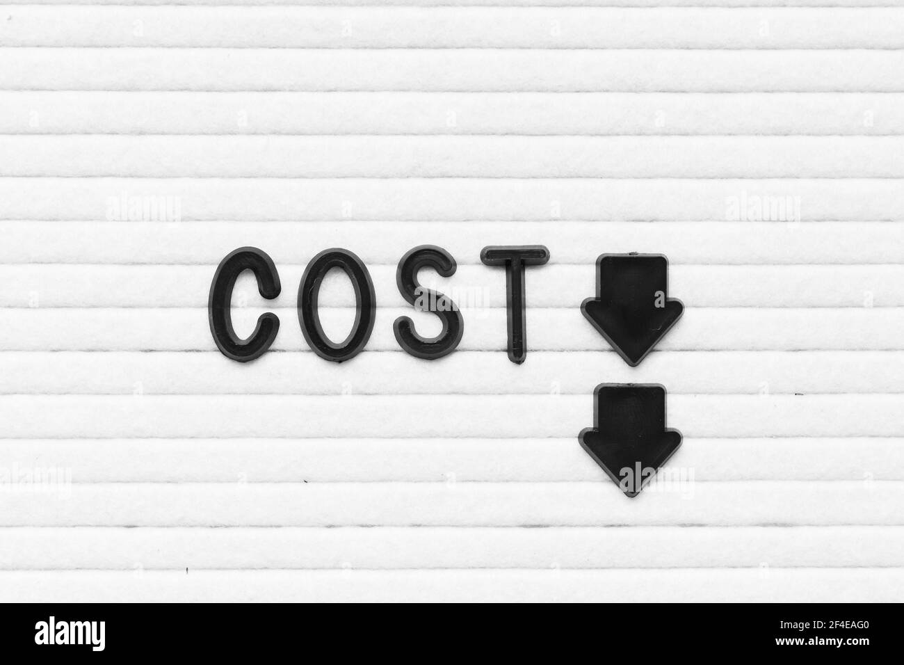 Black color letter in word cost with down arrow on white felt board ...