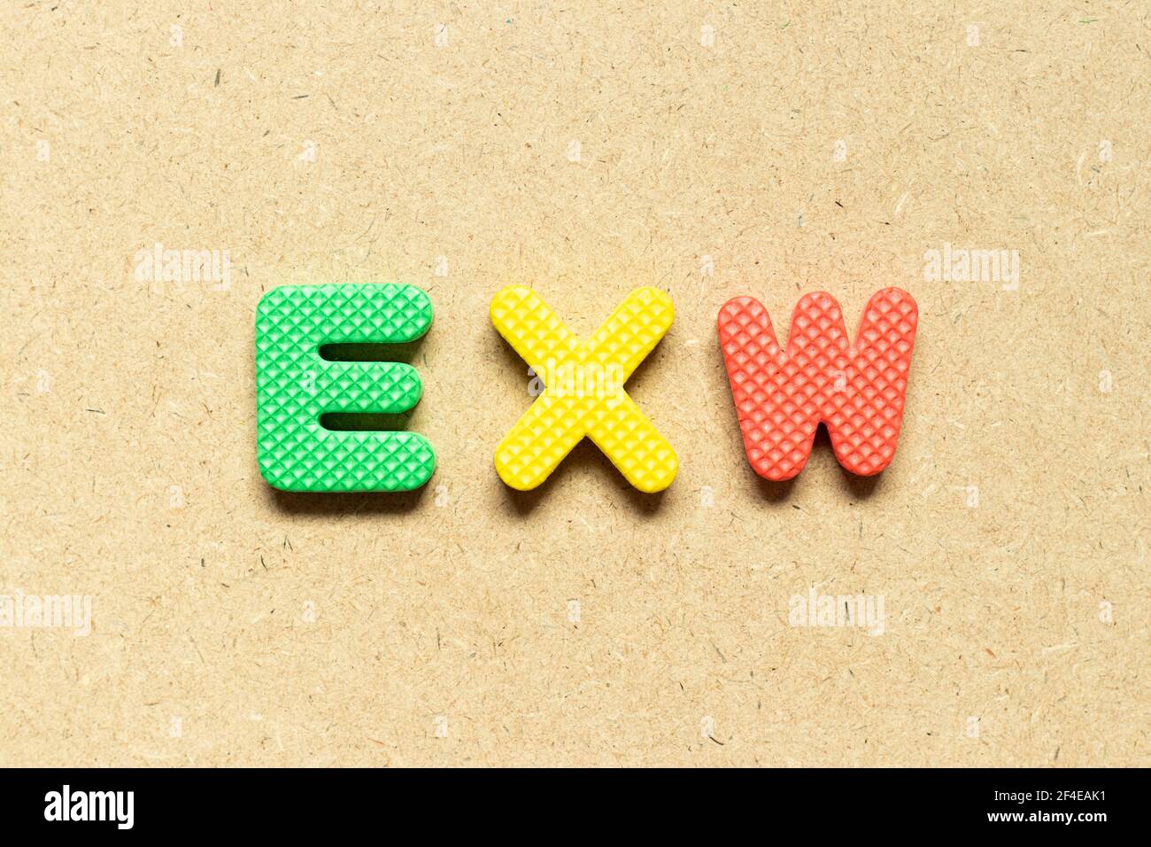Foam alphabet letter in word EXW (abbreviation of Ex works) on wood ...