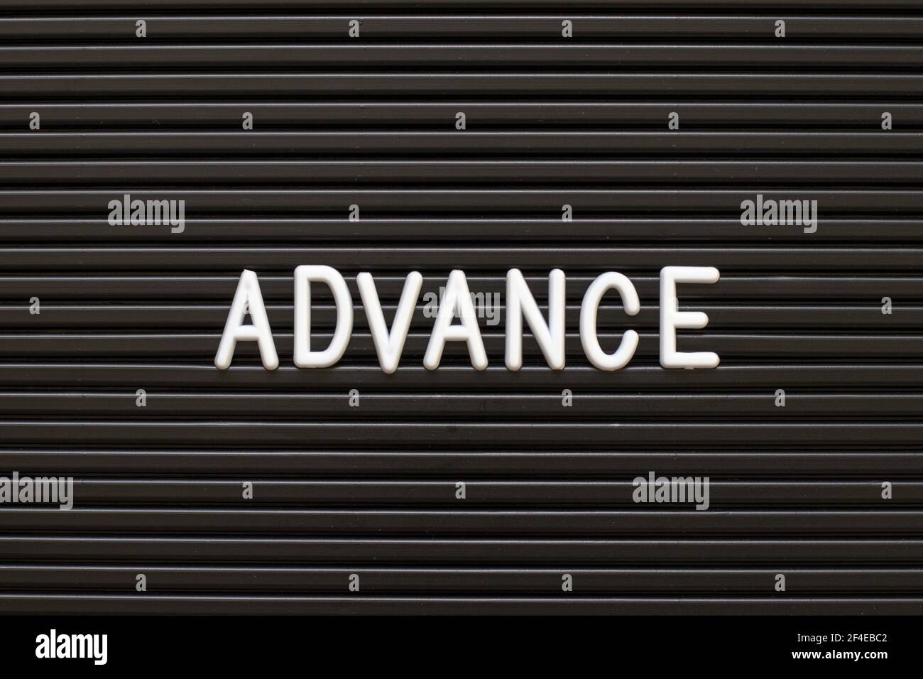 White alphabet in word advance on black color felt letter board ...